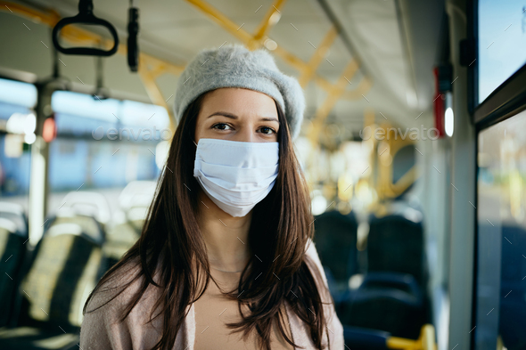 Female commuter wearing protective face mas in a public transport. Stock Photo by drazenphoto